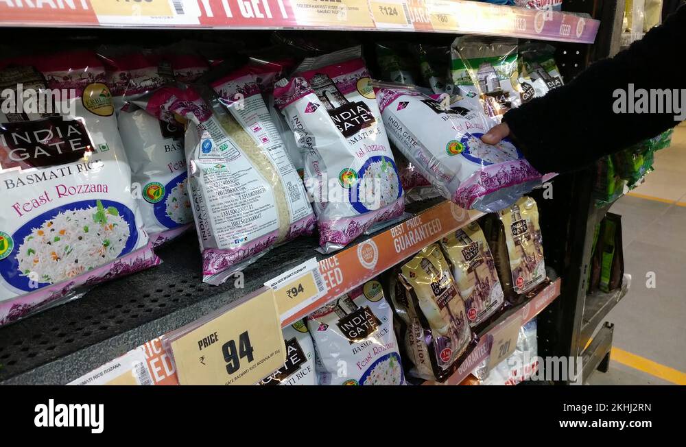 Woman in black coat picking up and checking back of packet of India ...