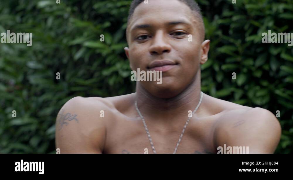 Shirtless young black man looking sternly like a thug at the camera ...