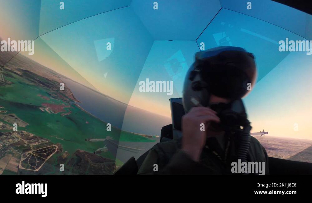 U.S. Air Force pilot releasing flying helmet in F-16 flight simulator ...