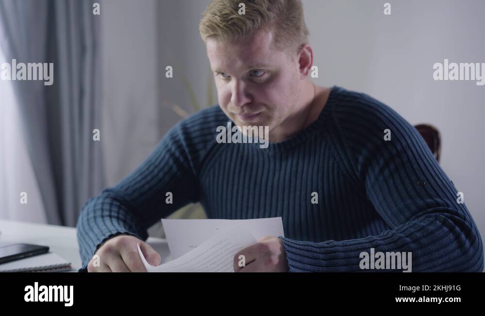 Camera approaching to face of sad Caucasian man sitting at the table ...