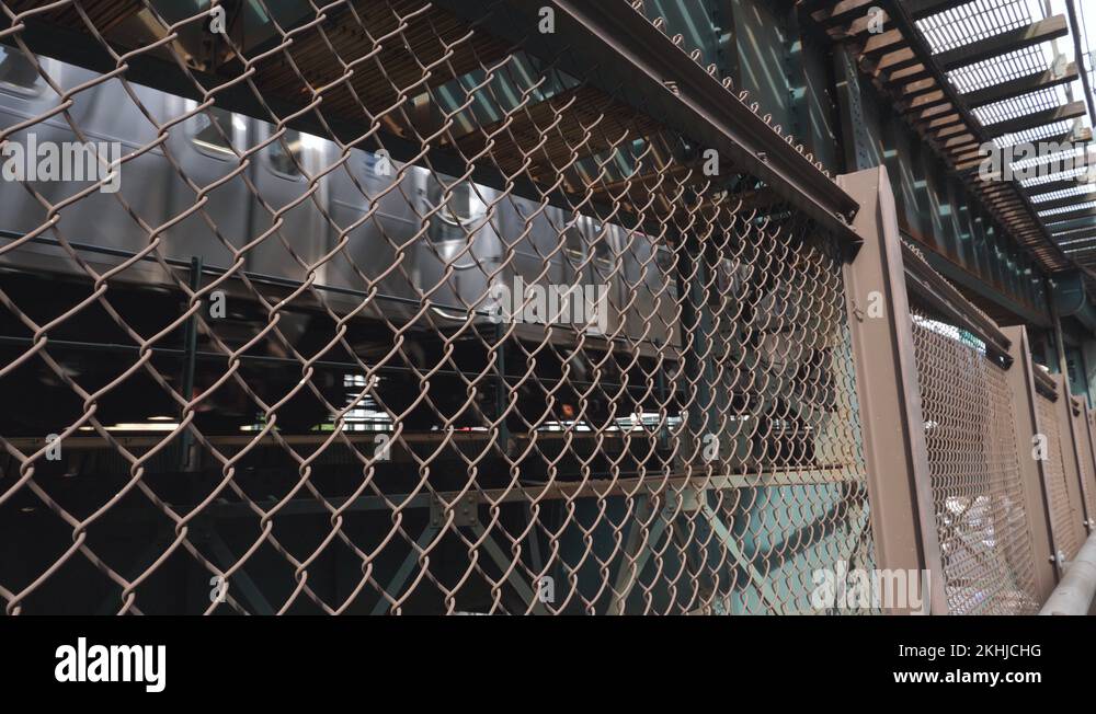 Passing subway train and chain link fence. Queens, New York City Stock ...