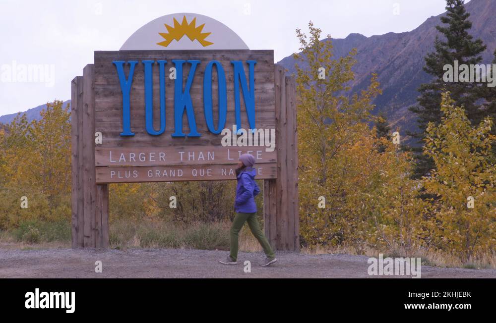 Yukon territory welcome sign - happy tourist woman in canadian ...