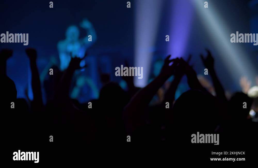 Super slow motion: silhouettes of people partying and clapping at rock ...