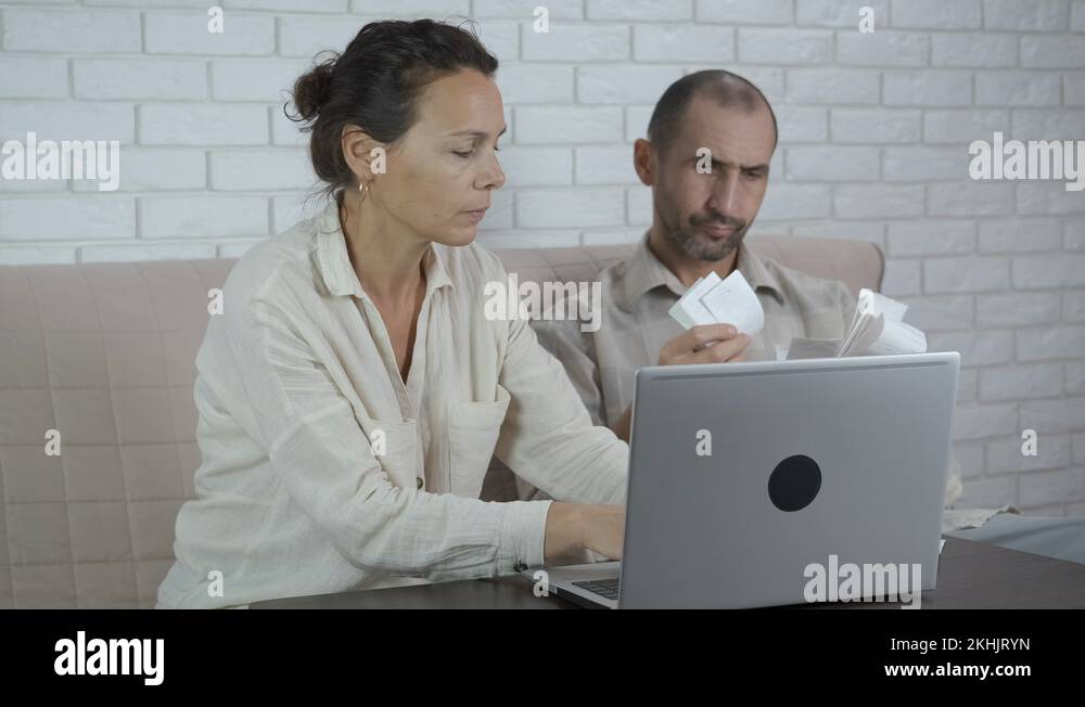 Calculate taxes. Husband and wife count checks Stock Video Footage - Alamy