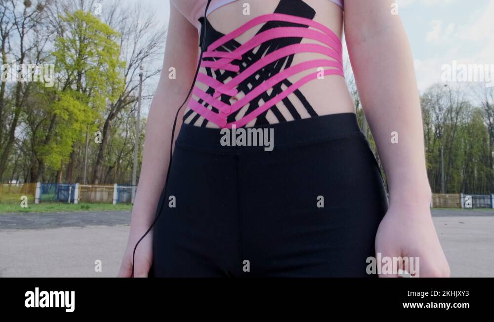 caucasian girl with kinesiology tape on her belly and chest posing in ...