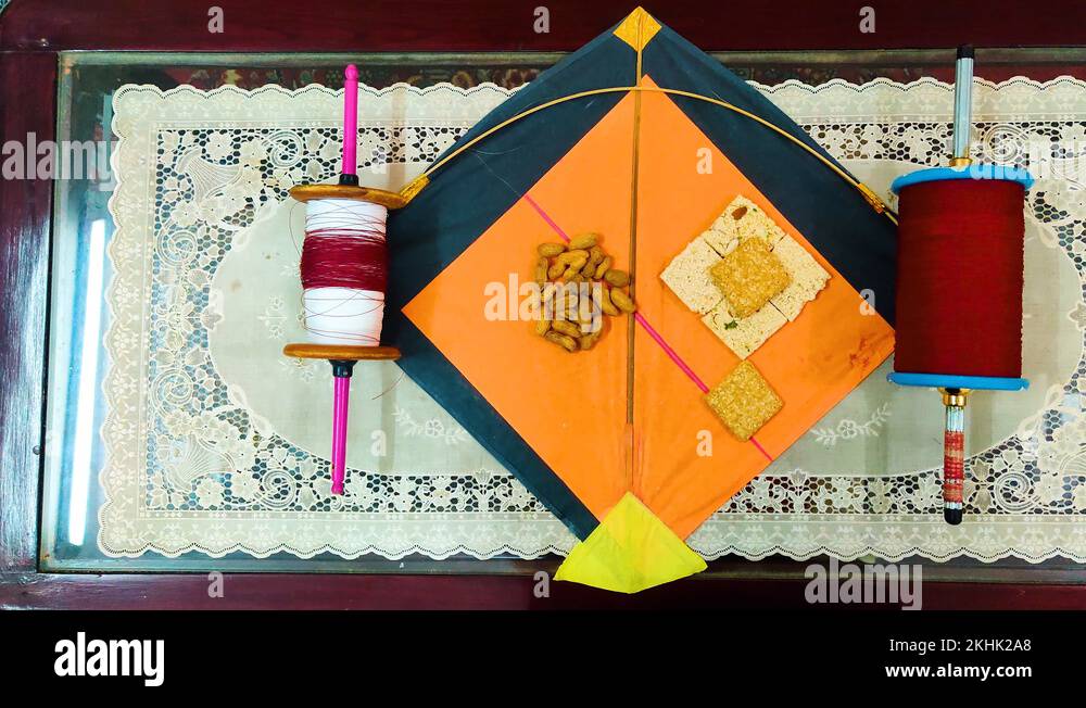 Video of a colourful reel of thread with a bright orange kite from left ...