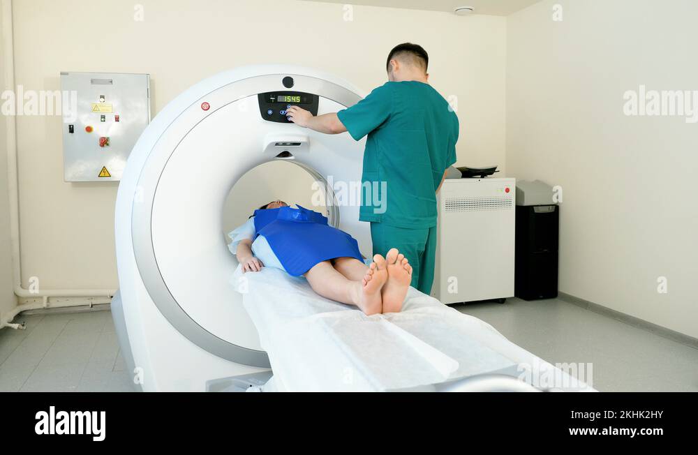 Female patient is undergoing MRI or CT scan under supervision of ...