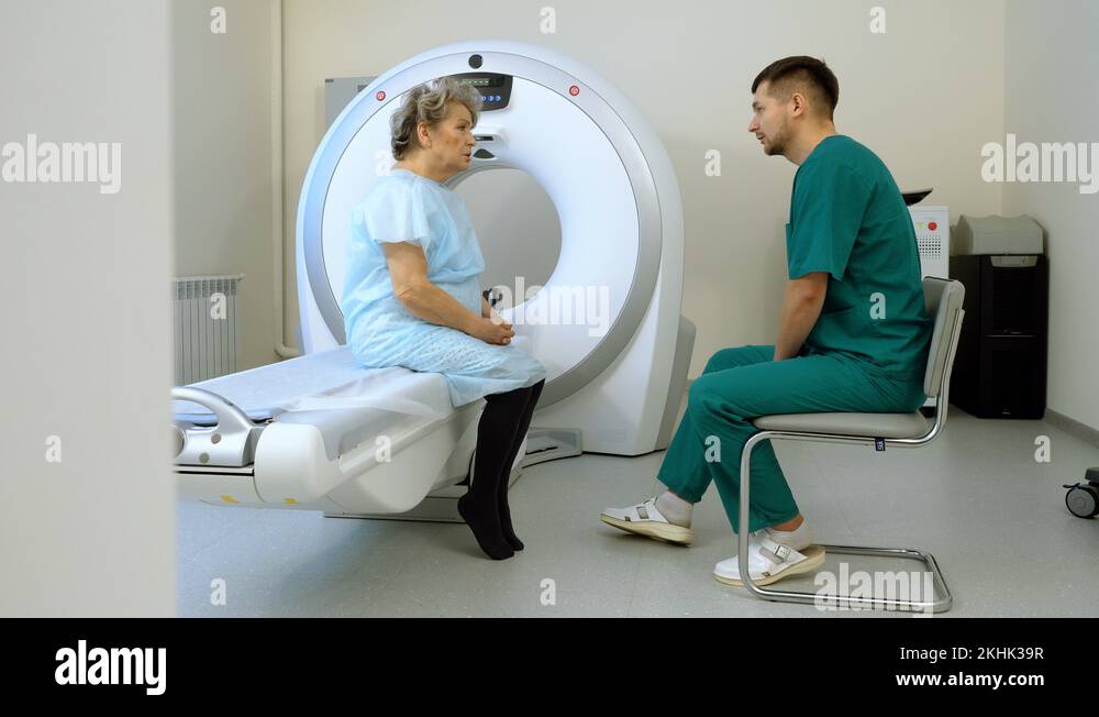 Doctor talking to elderly female patient. MRI or CT scan in modern ...