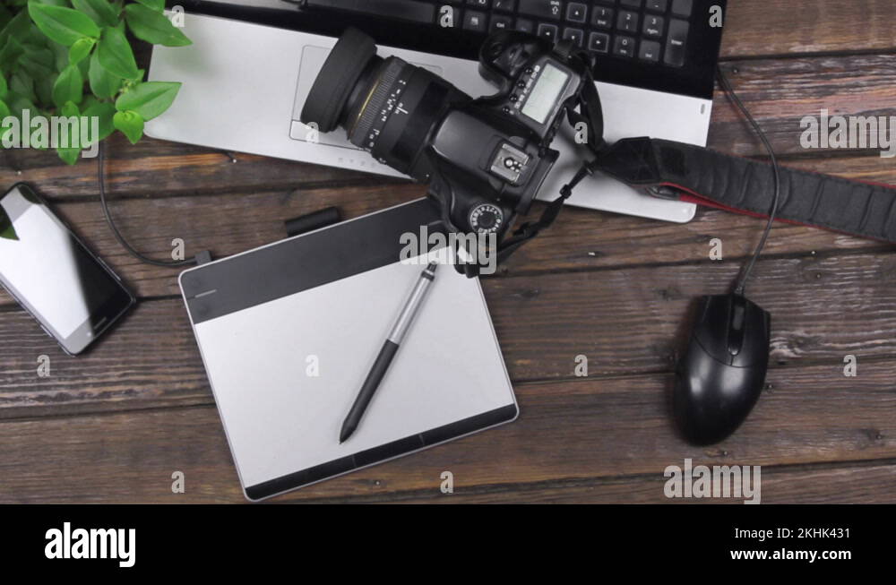 Zoom, office desk focus on a camera lying on a laptop. Crane shot Stock ...