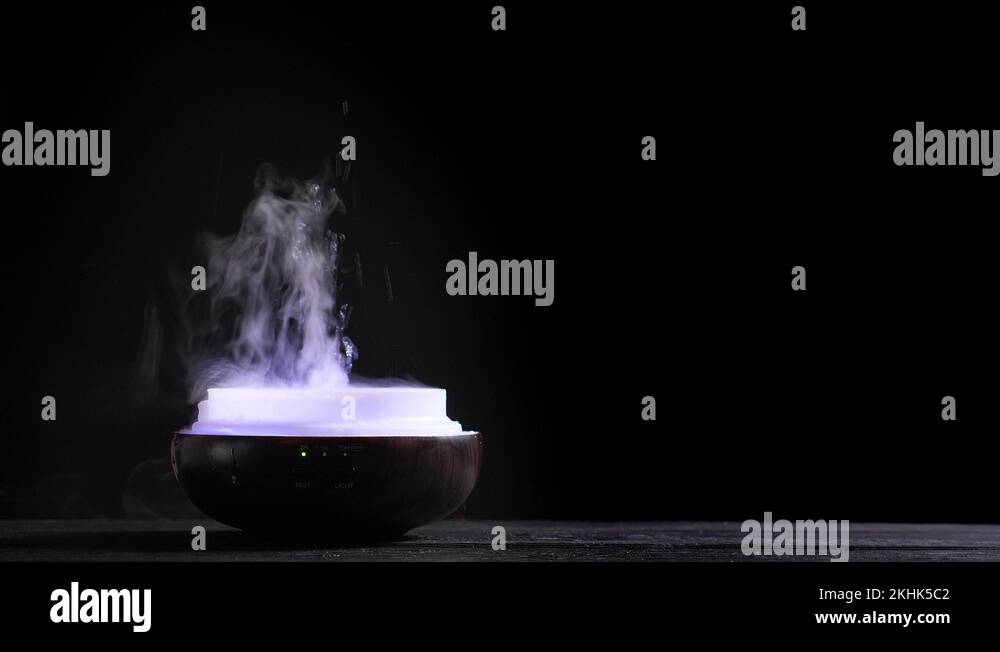 Open diffuser for essential oils diffusing steam on black background ...