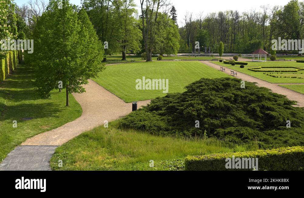 A beautiful well kept, green park with pathways, small shed and a ...