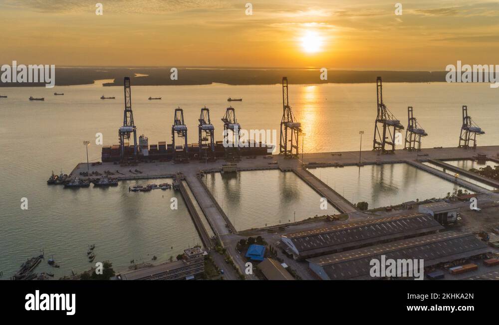 aerial view of crane at port area lifting container into vessel in 4k ...