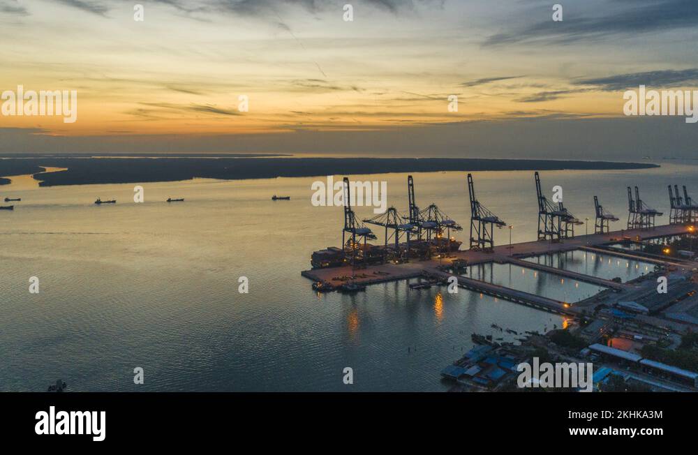 aerial view of crane at port area lifting container into vessel in 4k ...