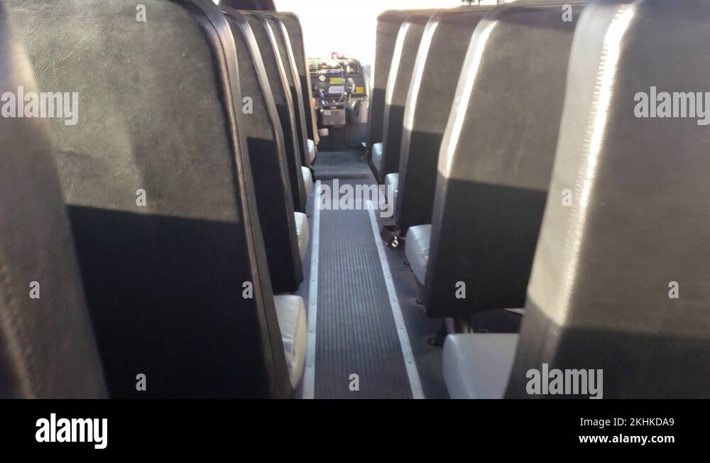POV walking down middle aisle of school bus as doors open - reveal a ...