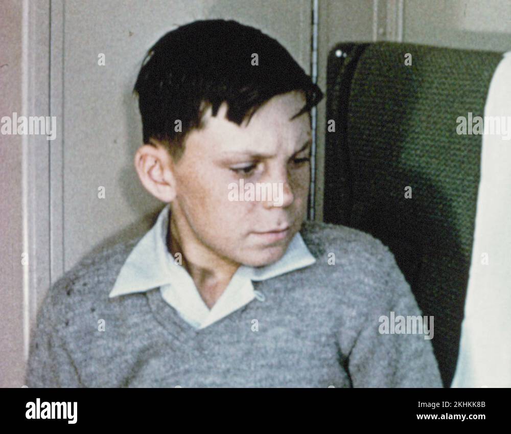 1950s: Boy sits in seat on train talking to other boy. Two boys playing ...