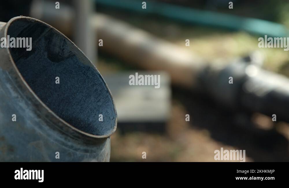 Drilling mud and rock debris flowing in plastic pipe from borehole ...