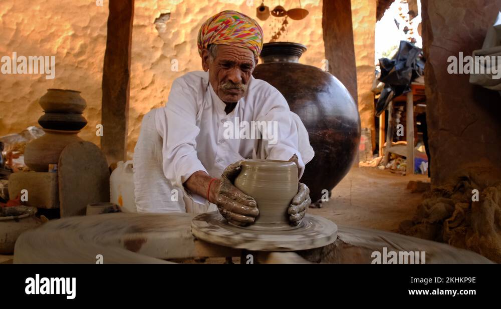 Indian potter at work: throwing the potter's wheel and shaping ceramic ...