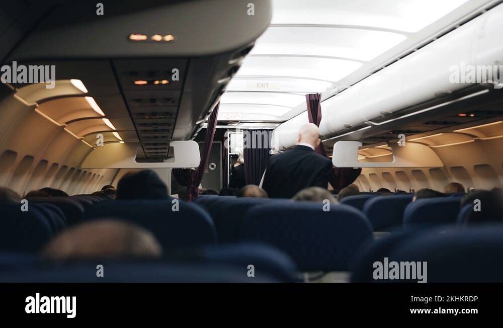 The aircraft cabin during the flight. Stewart walks down the aisle. Air ...