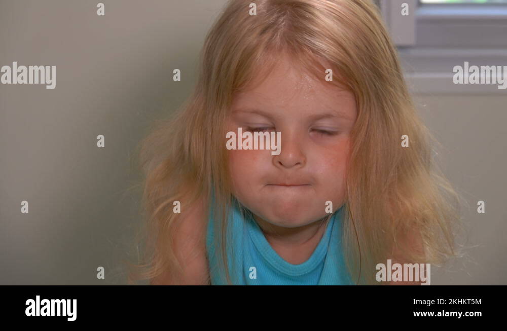 Cute blue-eyed girl bites her lips with sadness Stock Video Footage - Alamy