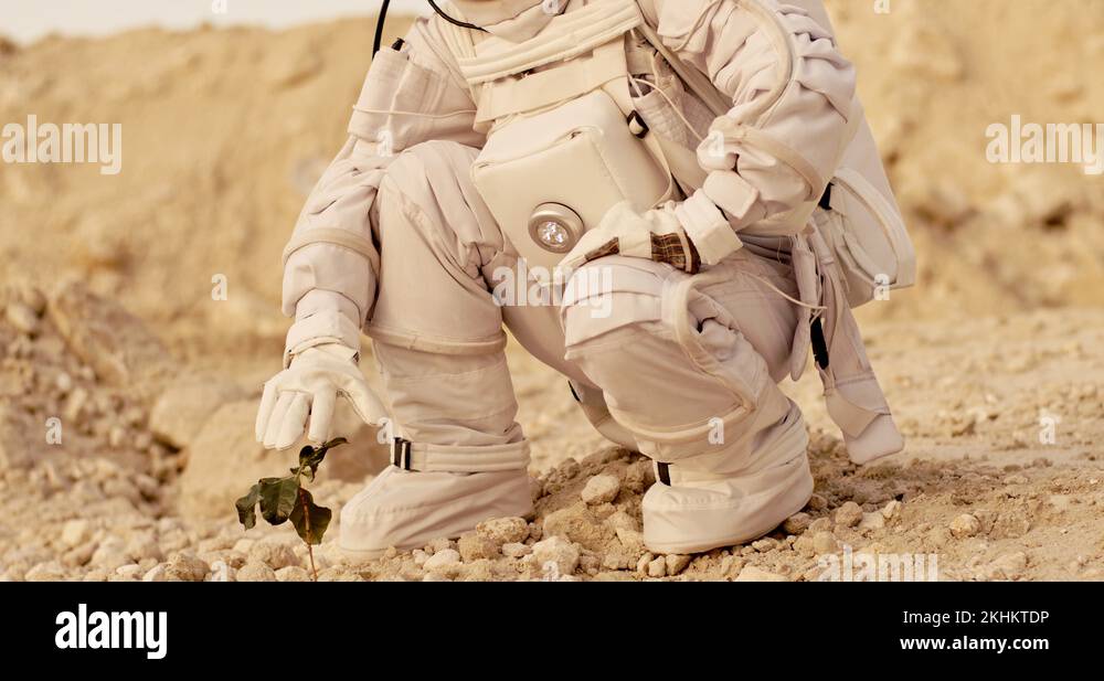 Cosmonaut in the white space armor and helmet on his head touching ...