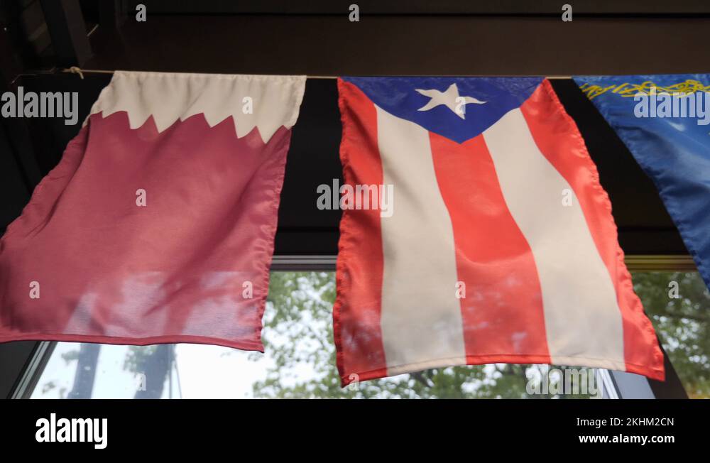 Close up of group of flags. Flags of different countries hang on wall ...