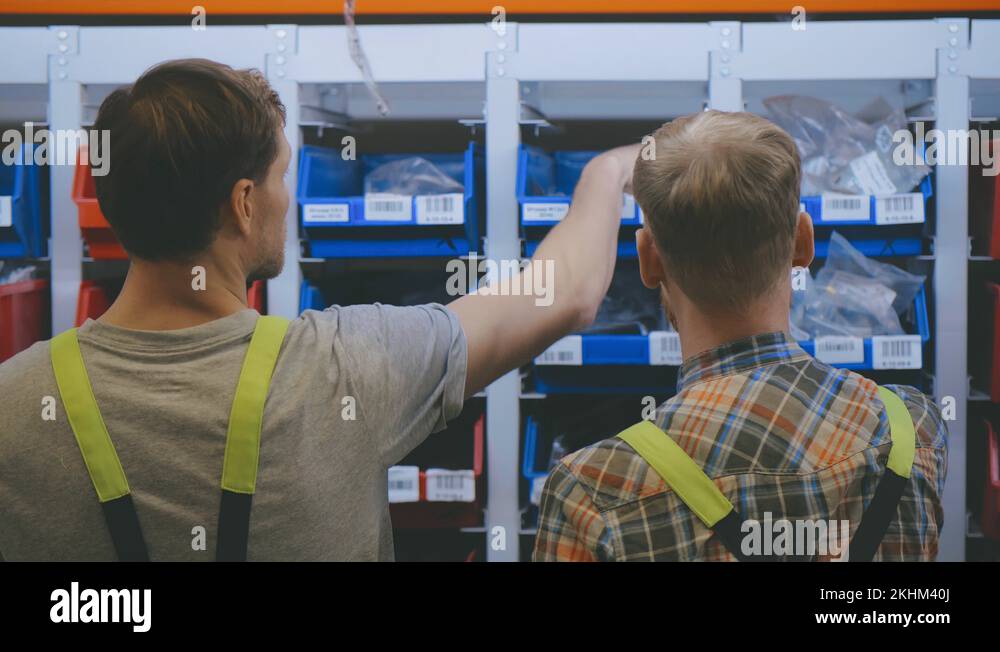 Back view of two young men choosing repair parts in warehouse Stock ...