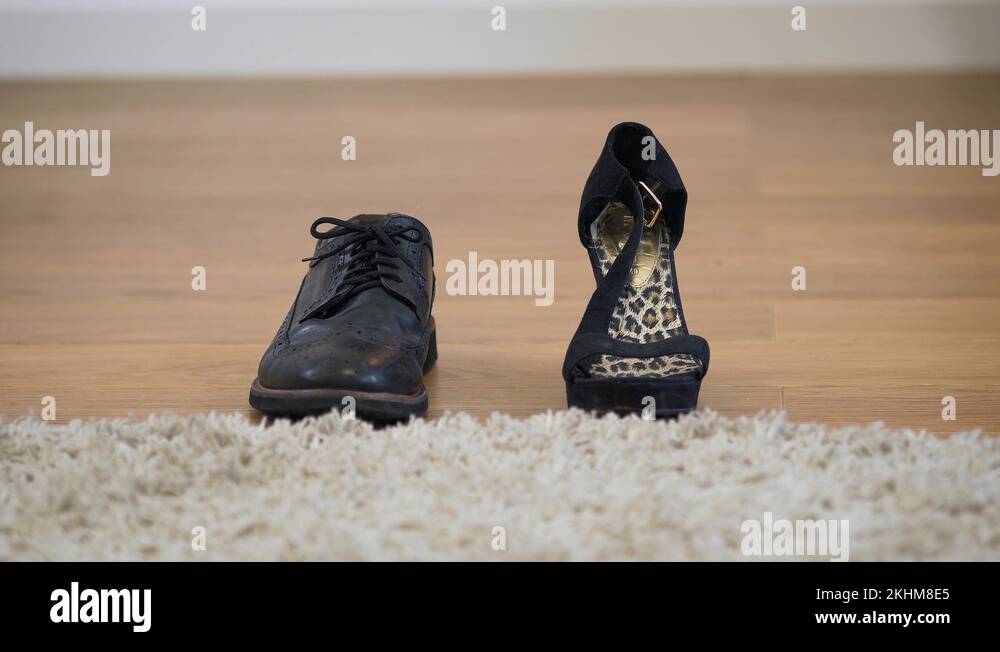 Men's boot and women's high heel shoe standing on the floor, male ...