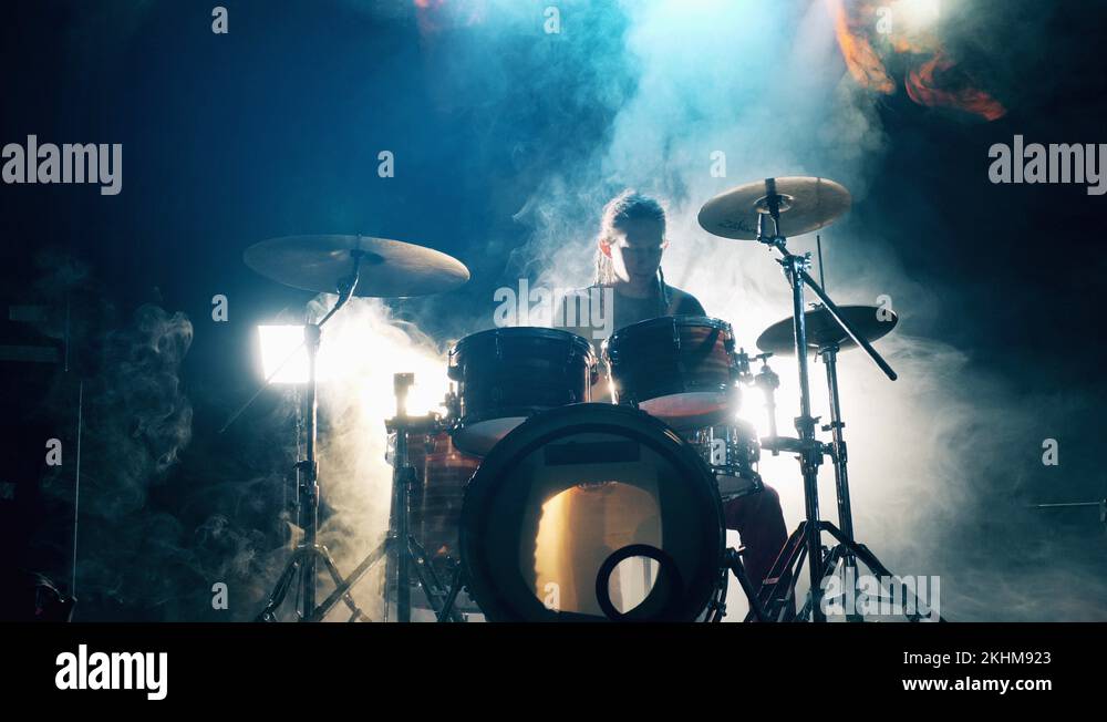 Musician is playing the drum set in the dark clouded studio. Male ...