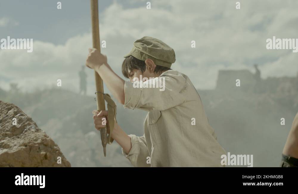 Young miner boy is working in a quarry . Many workers are mining with ...