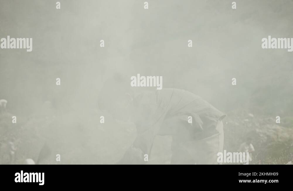 Young miner boy working in quarry . Many workers mining with pickaxe in ...