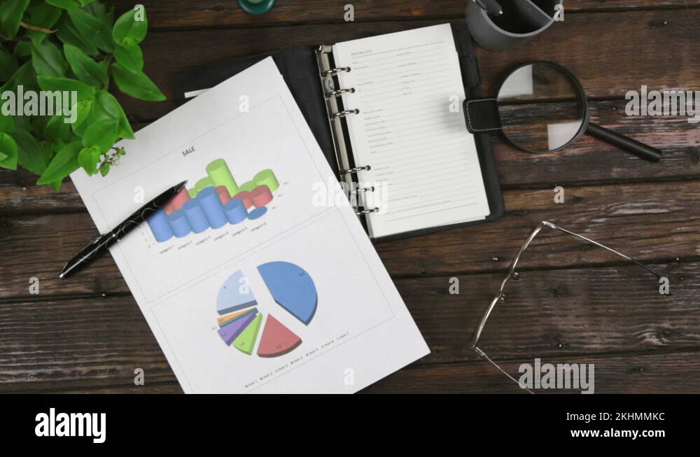 Zoom. Office desk, focus on chart, diary and magnifying glass. View ...