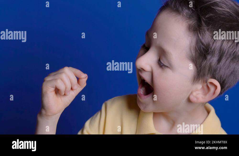 Little smiling boy hand pointing his first baby milk or temporary tooth ...