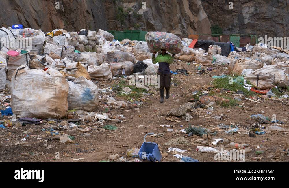 Poor woman, poverty,carrying plastic bag on her head,collected at a ...