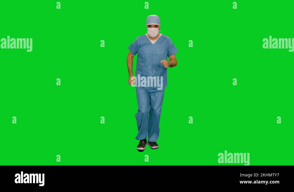 Surgeon in mask rushes to provide urgent medical care on green screen ...