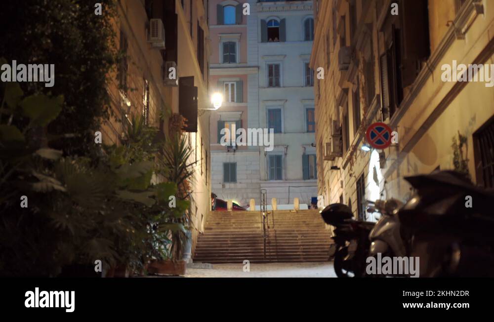 Long narrow Roman street at night, marble stairs leading to the city ...