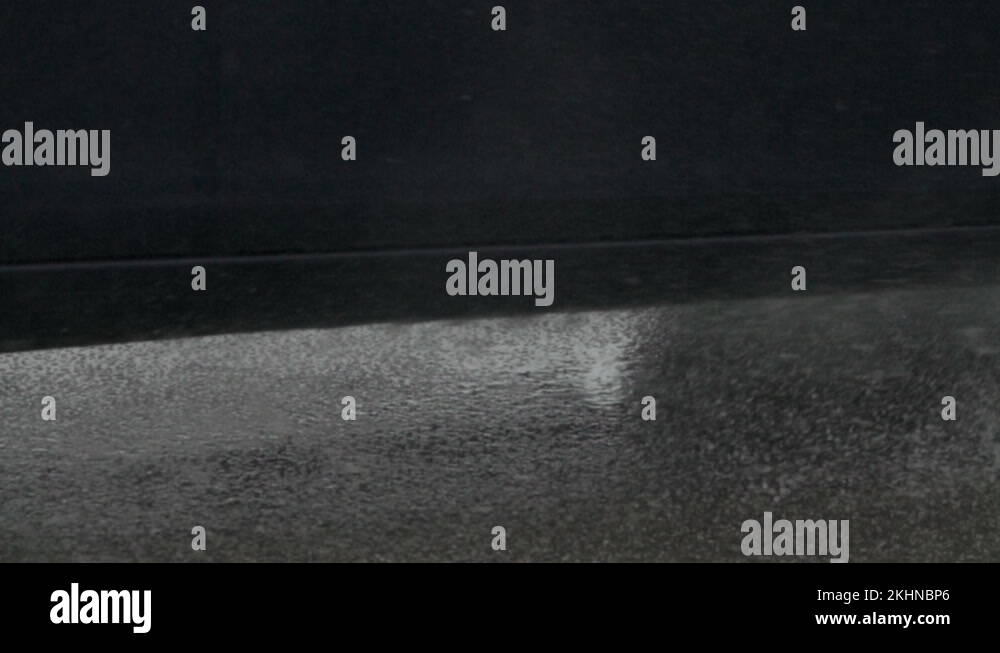 Splash by a car as it goes through flood water. Car driving on urban ...