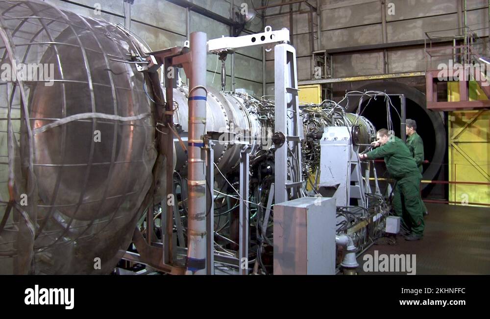 Specialists inspect jet engine after repair. Engine is installed on ...