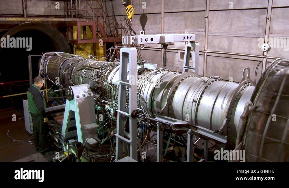 Specialists inspect jet engine after repair. Engine is installed on ...