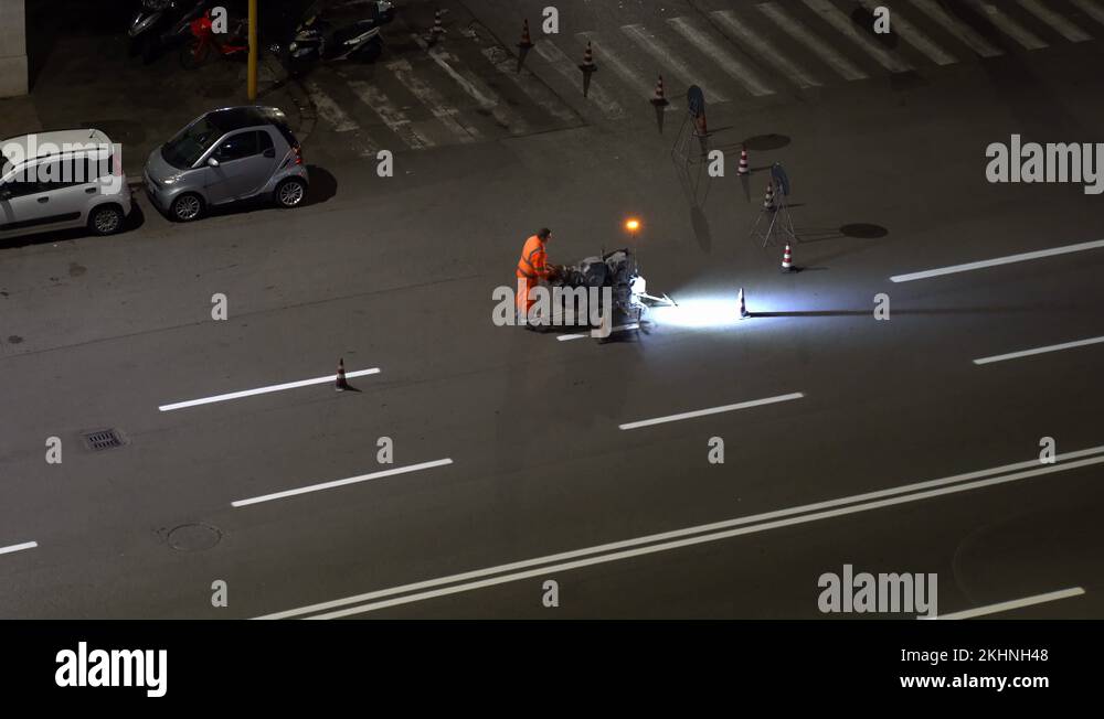 Traffic signs blocking road at night, worker in uniform using blinking ...