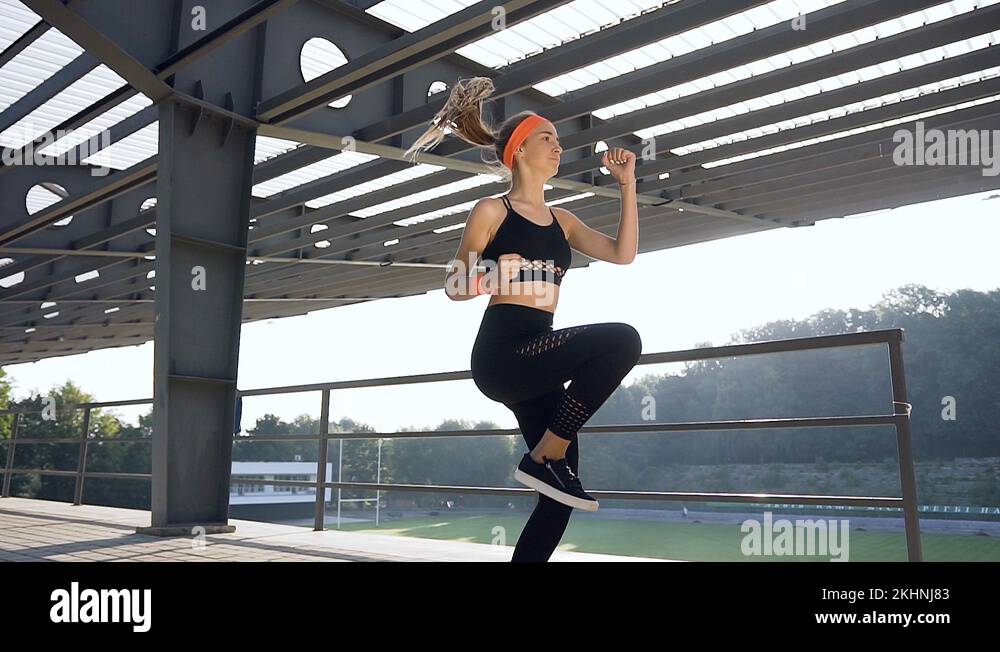 Flexible athletic young girl in fitness clothes running on the spot ...