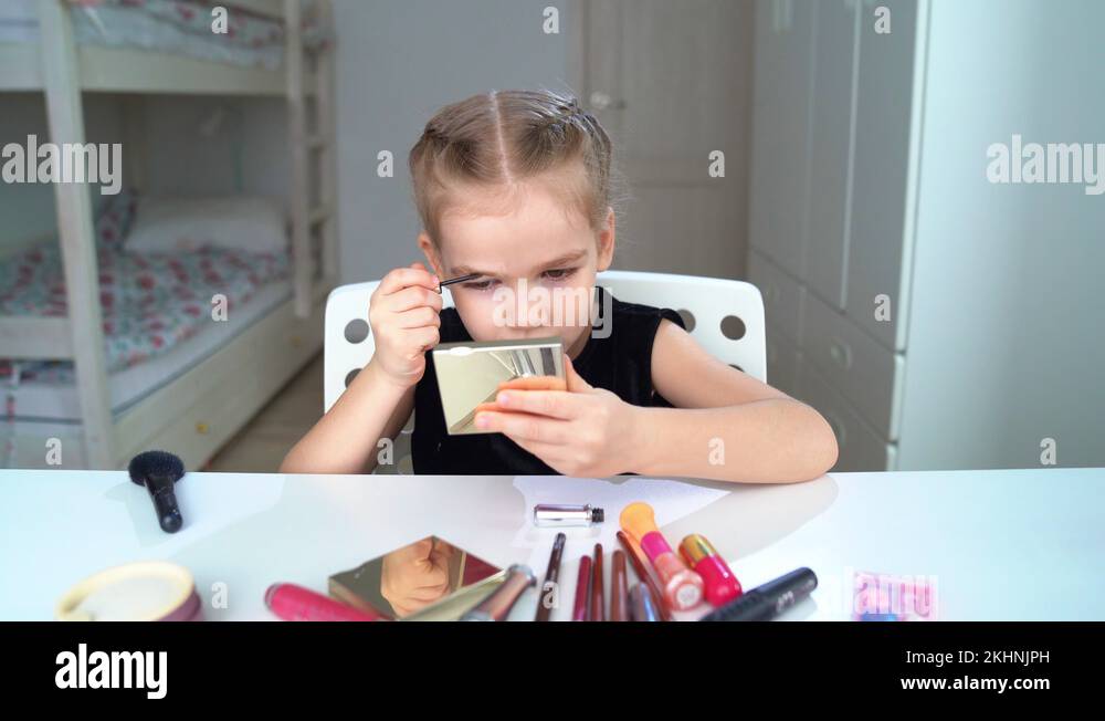 Little girl doing the makeup at home. Beauty blogger. Paint the ...