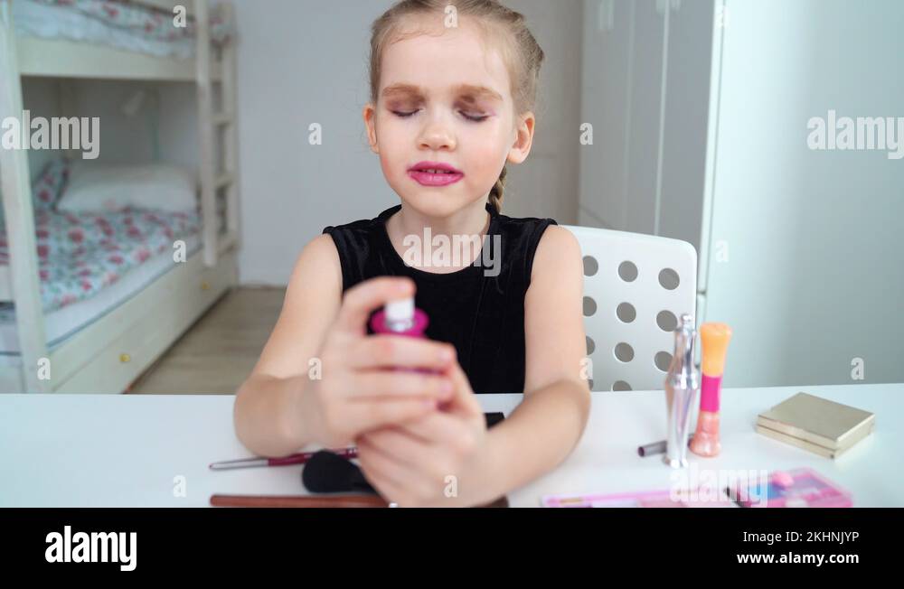Little girl doing the makeup at home. Beauty blogger. Moisturizes the ...