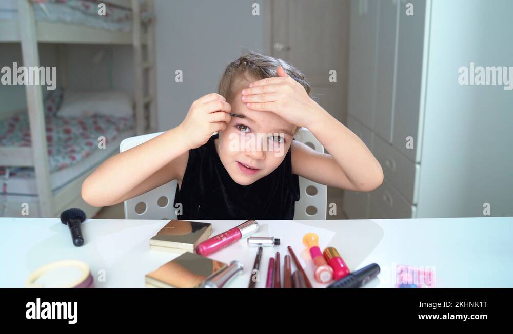 Little girl doing the makeup at home. Beauty blogger. Paint the ...
