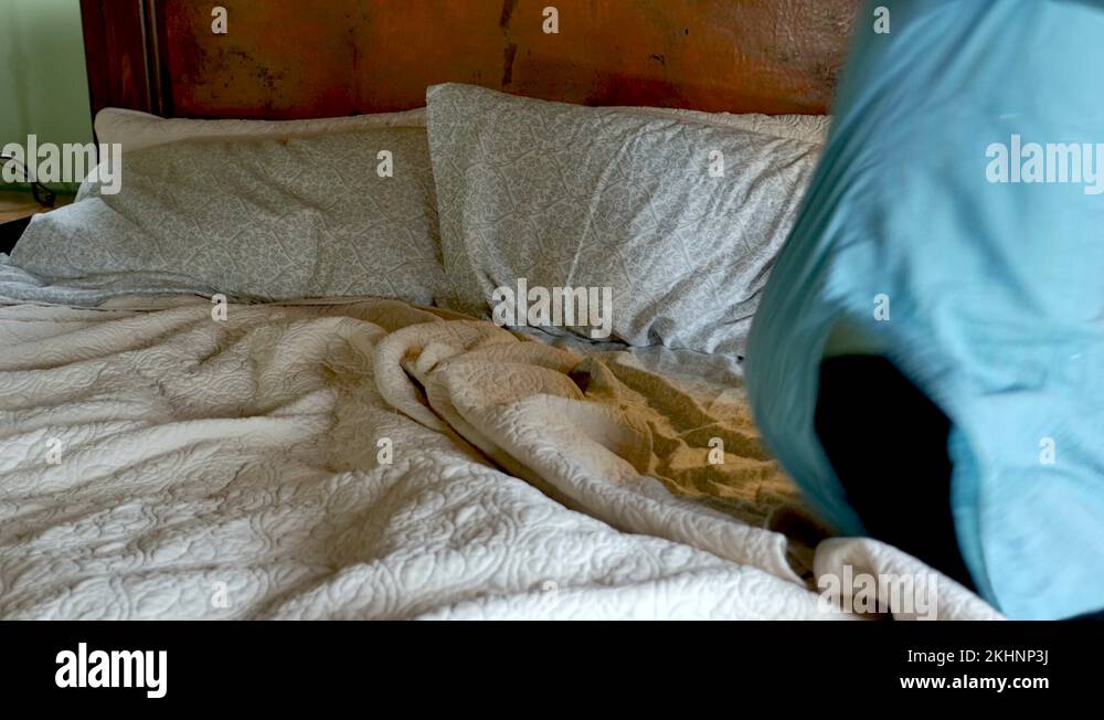 African American senior black woman falling on her back on her bed ...