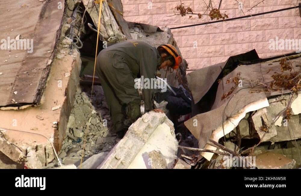 Female soldier searches for earthquake casualties digging through the ...