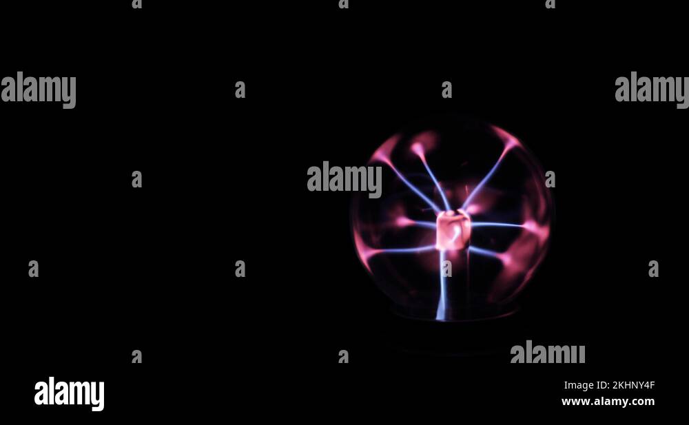 Tesla plasma ball with electrode and pink and blue lightnings in dark ...