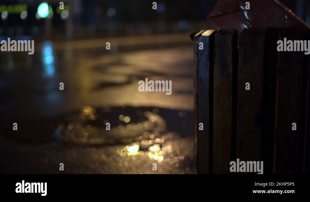 Rainy night city streets, street light reflected in rain puddles on sidewalk Stock Video Footage ...