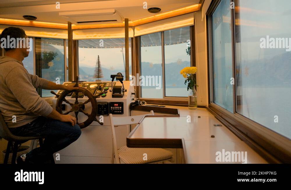 Man controls a steering wheel in a floating house on the sea Stock ...