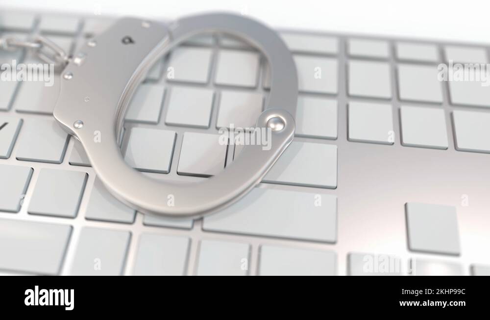 Handcuffs on keyboard with FELONY text. Computer crime related ...