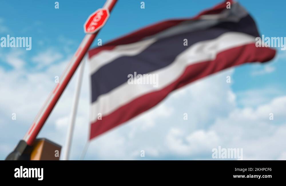 Closing boom barrier with stop sign against the Thai flag. Restricted ...